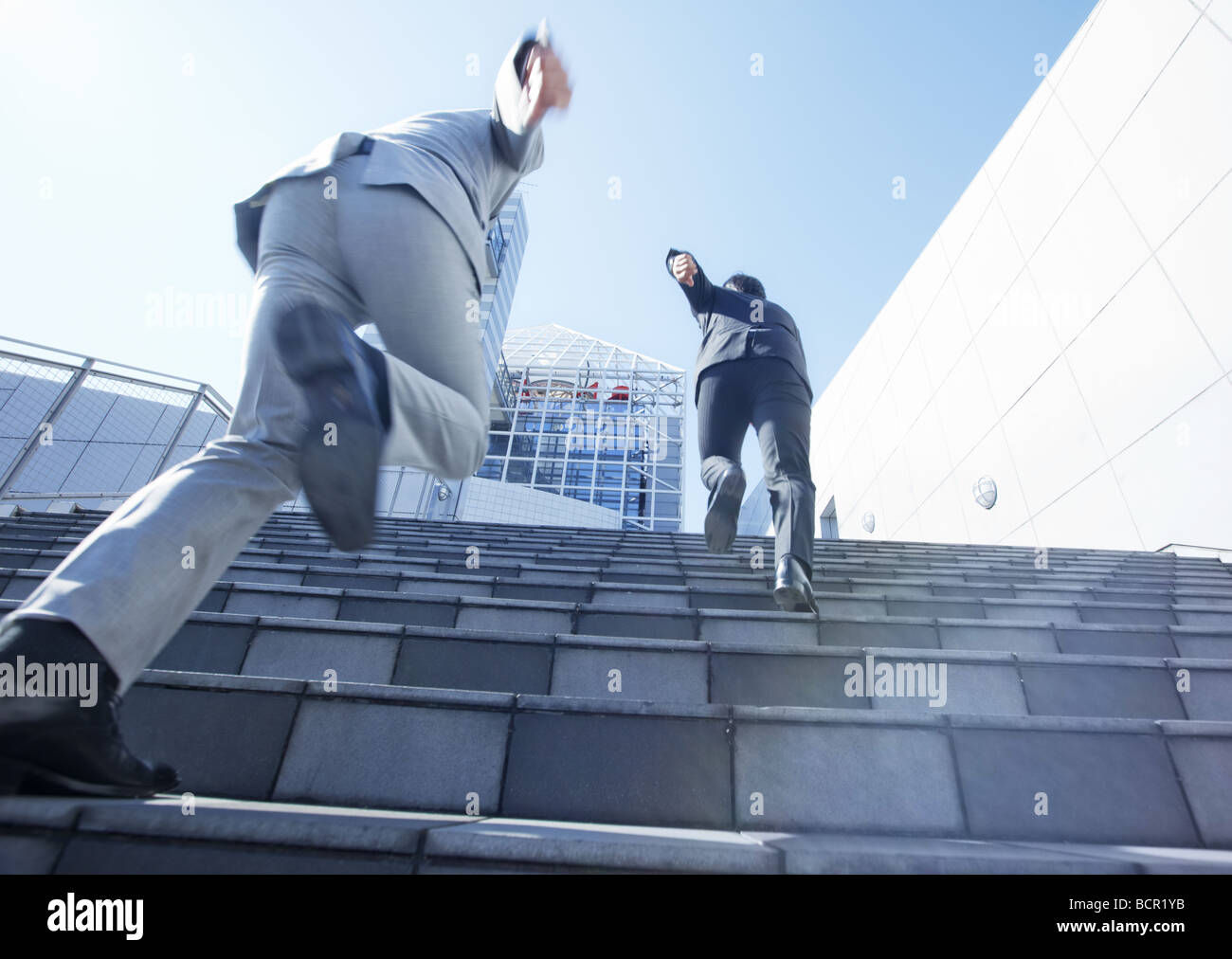 Businessmen running up stairs Stock Photo - Alamy
