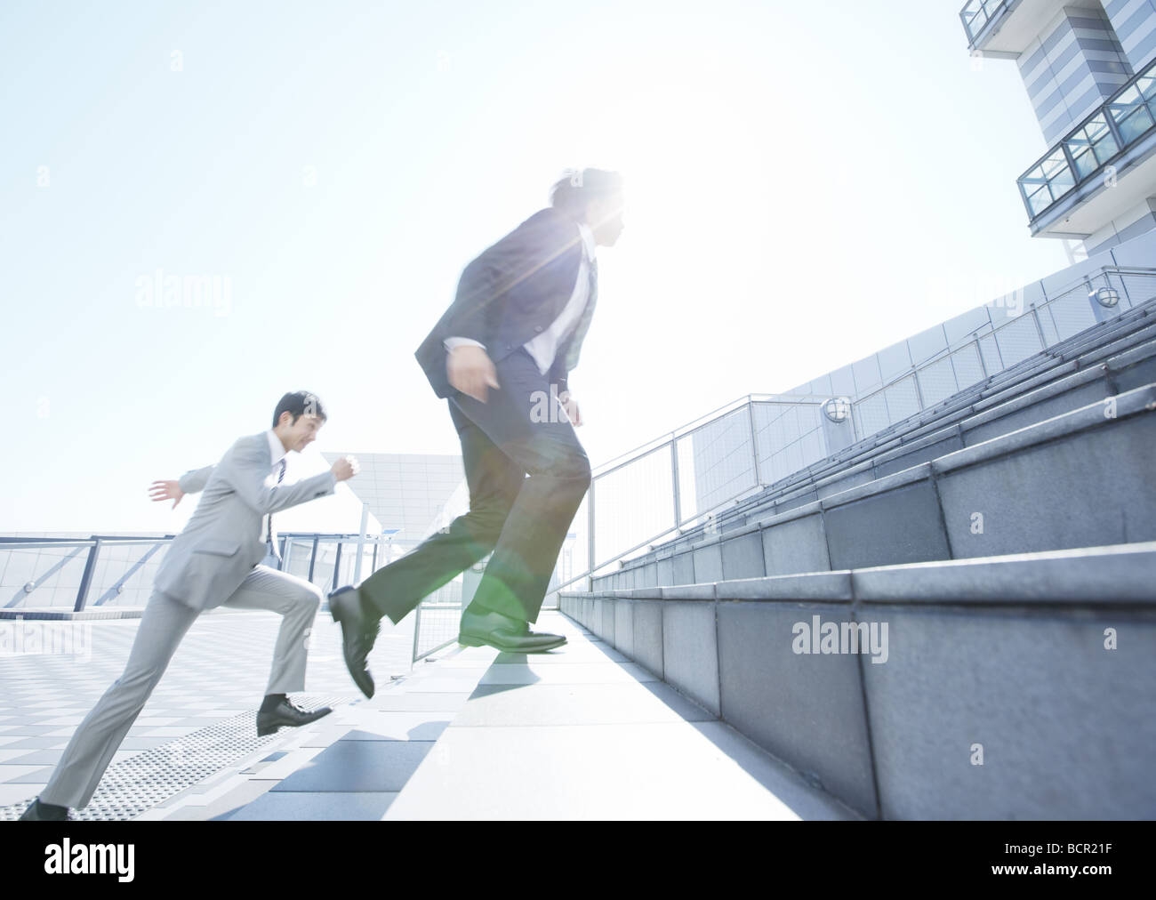 Businessmen running up stairs Stock Photo - Alamy