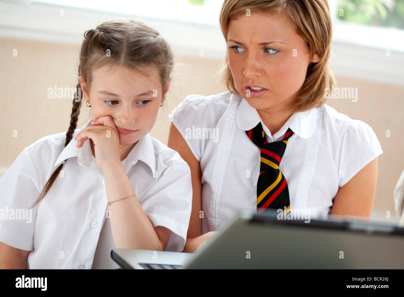 2 girls using on laptop Stock Photo - Alamy