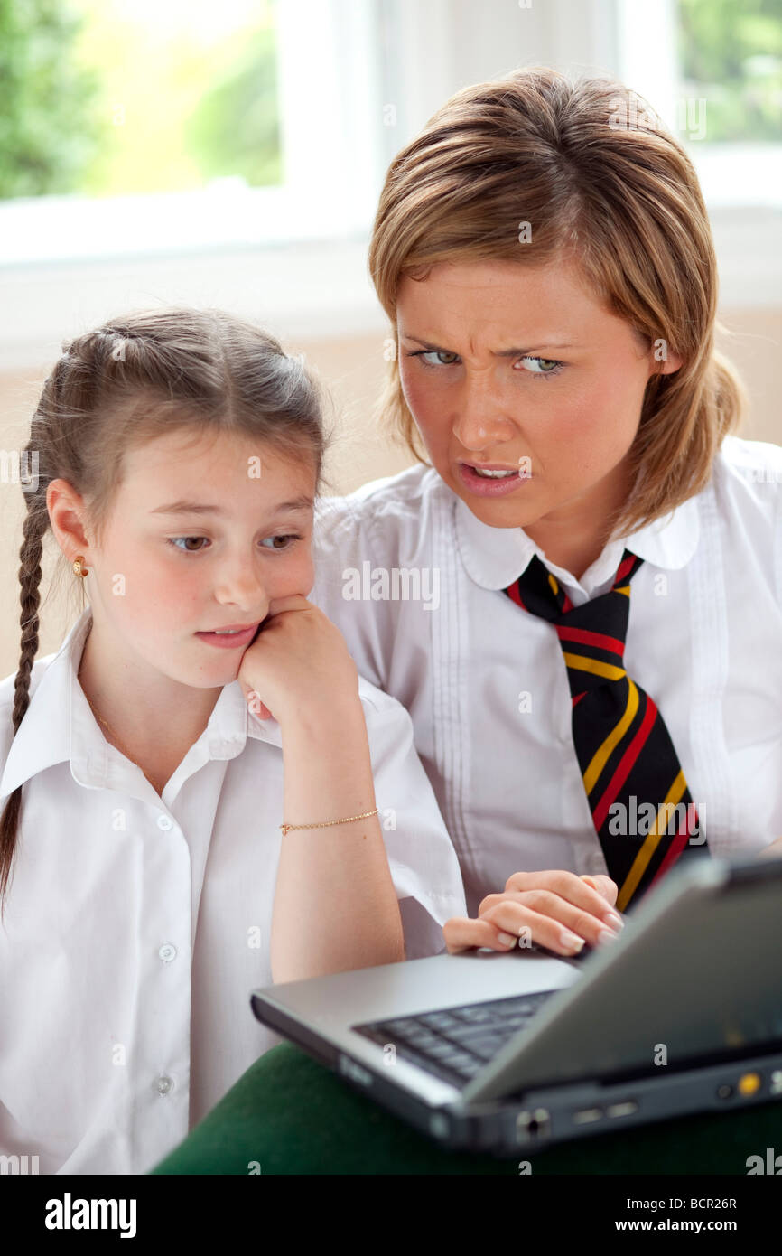 2 girls using on laptop Stock Photo - Alamy