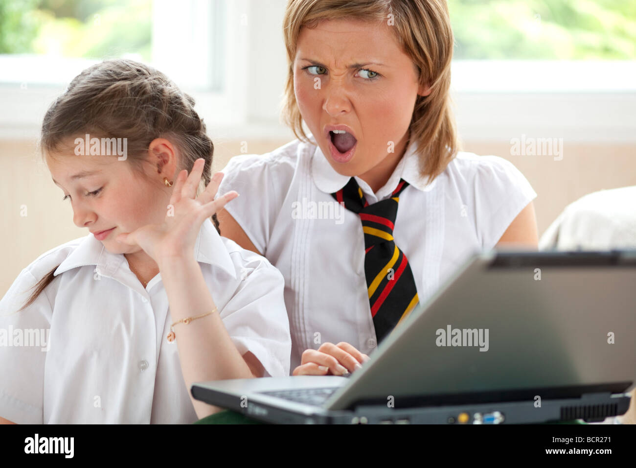 2 girls using on laptop Stock Photo - Alamy