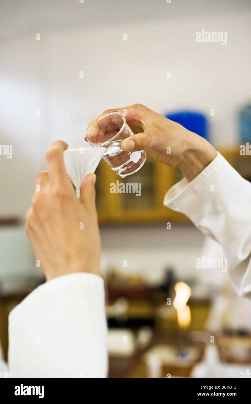 A student pouring liquid in a school science laboratory Stock Photo - Alamy