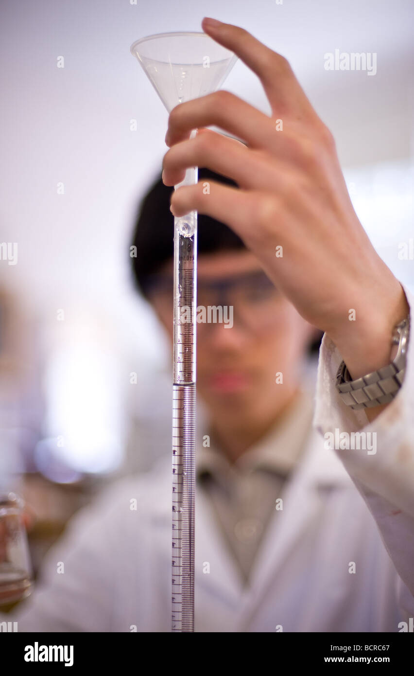 UK School A male student measuring liquid in a school science ...