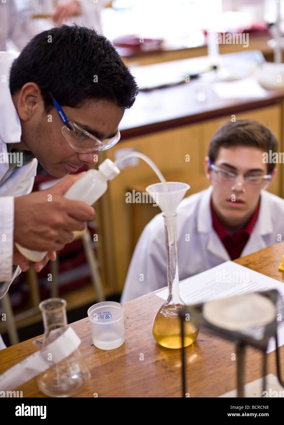 UK School An Asian student pouring liquid into a flask in a school ...