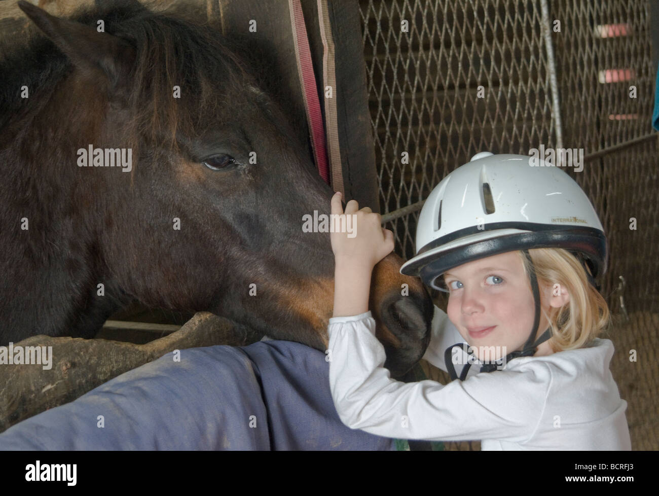 Young girl females with favorite horse in stable during horseback ...