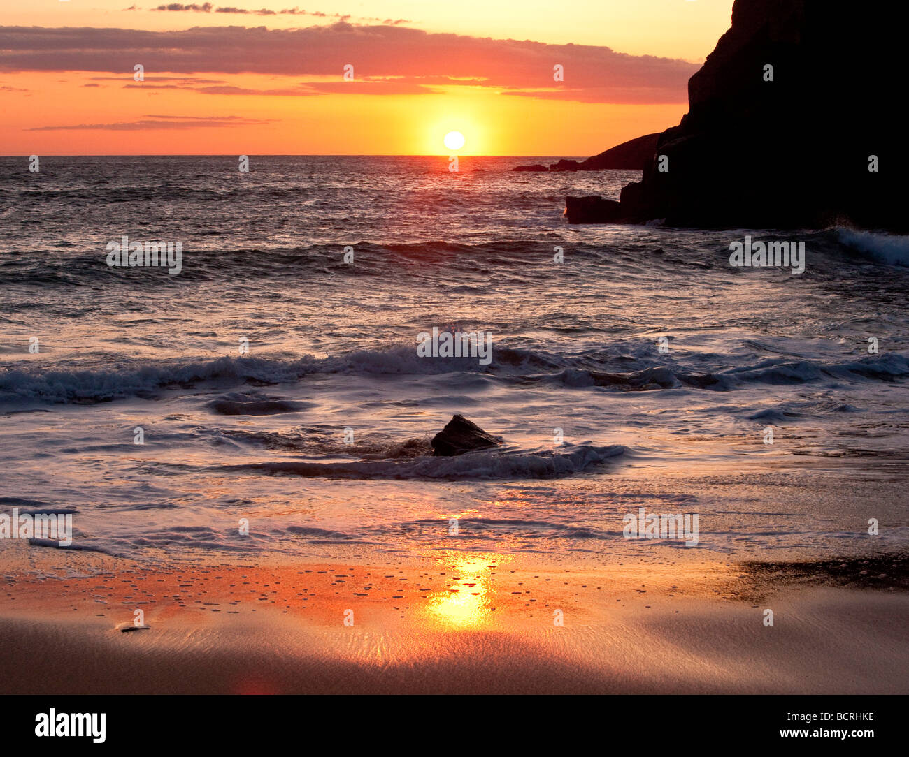 Sunset over beach and surf Stock Photo - Alamy
