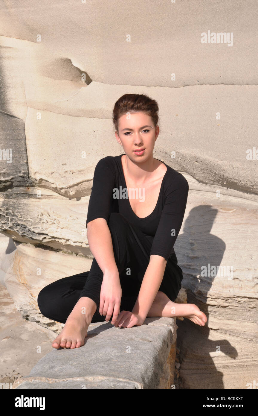 Young Girl sitting on rocks Stock Photo - Alamy