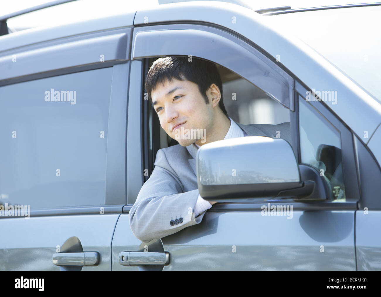 Businessman sticking his head out of car window Stock Photo - Alamy