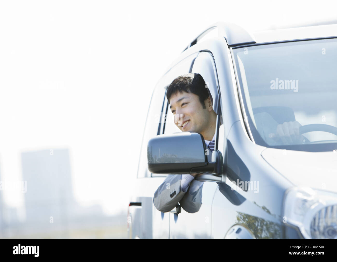 Businessman sticking his head out of car window Stock Photo - Alamy
