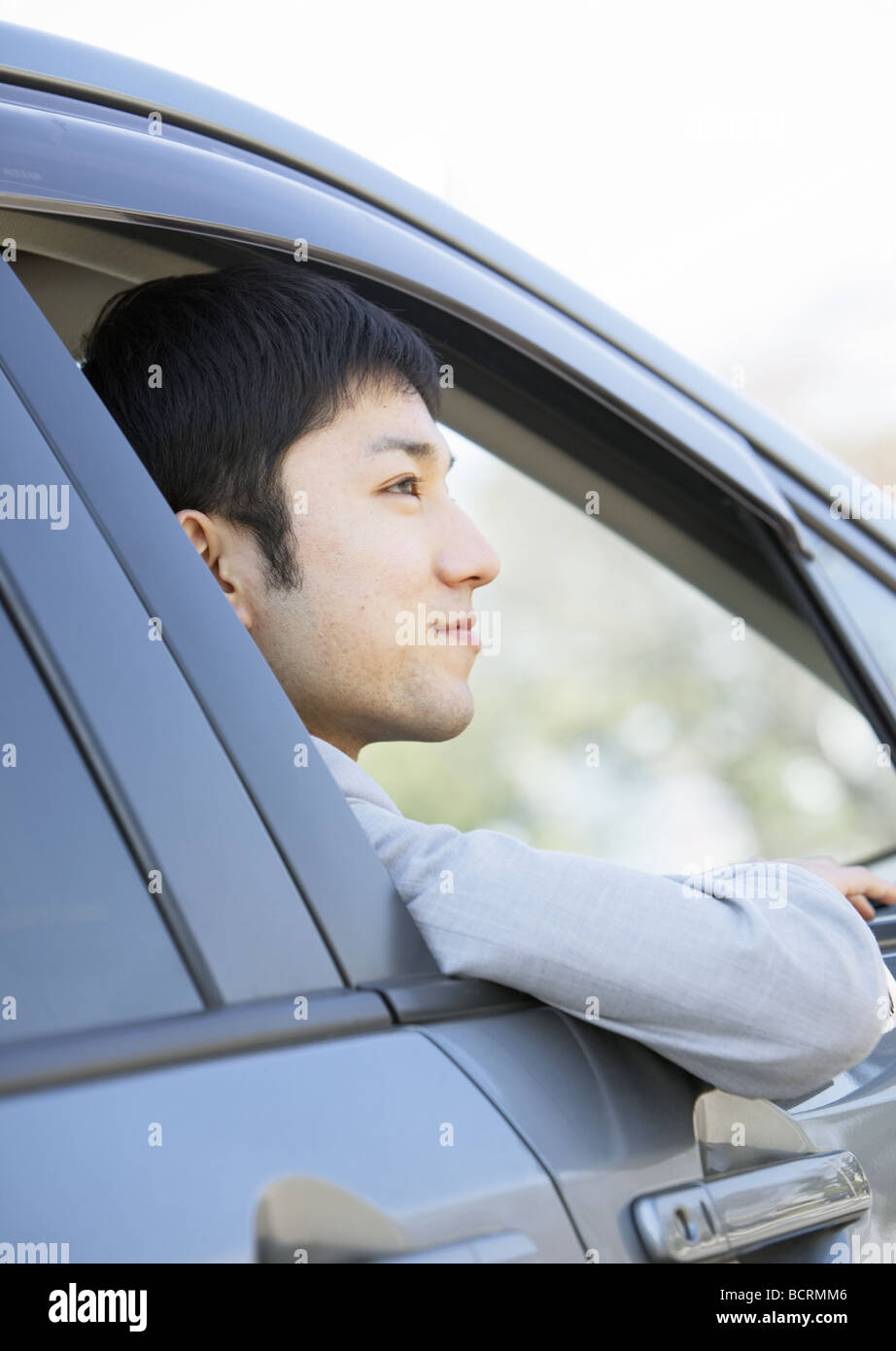Businessman sticking his head out of car window Stock Photo - Alamy