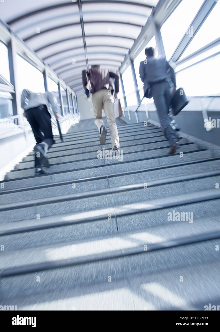 Businessmen running up stairs Stock Photo - Alamy