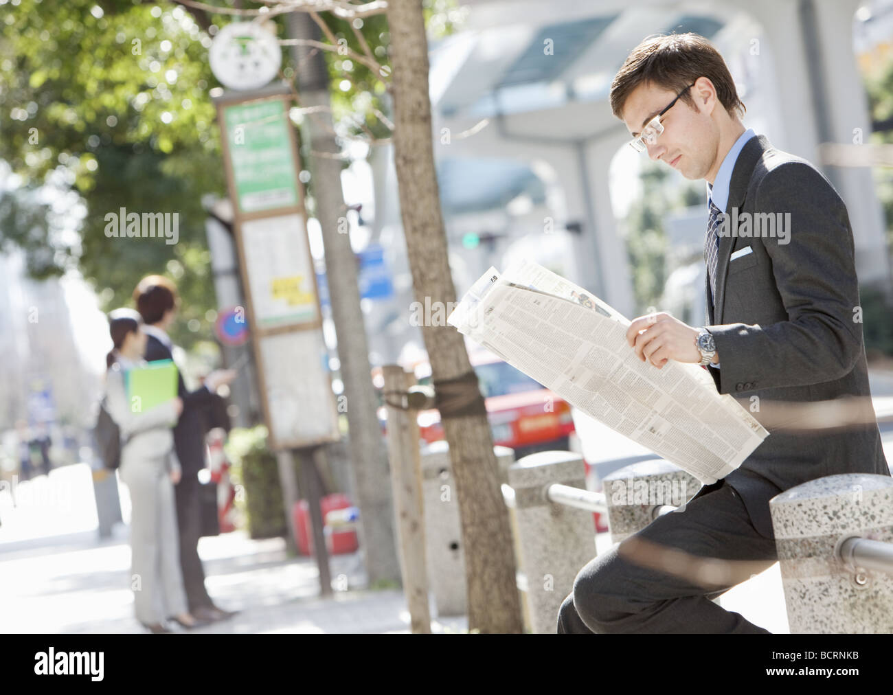 Reading newspaper bus stop hi-res stock photography and images - Alamy