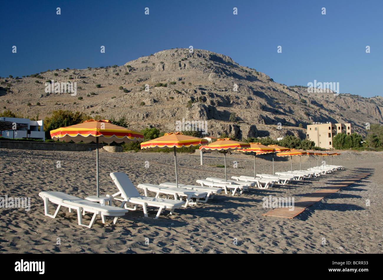 Deck chairs and parasols on sandy beach in Lothiarika near Lardos ...