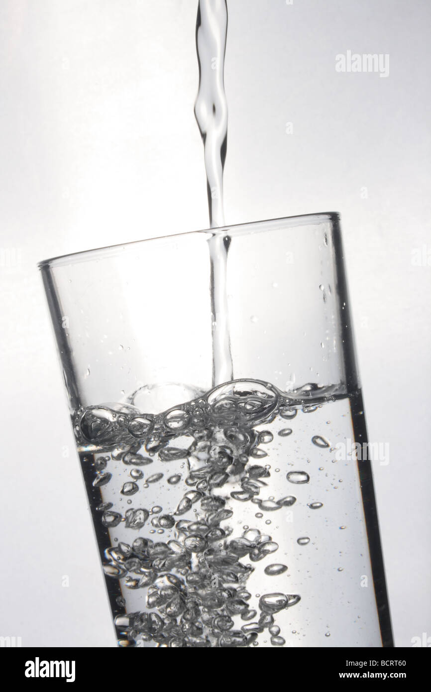 Clear glass being filled with water Stock Photo - Alamy