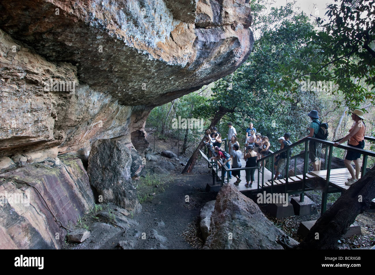 A group of tourists listening to a talk and looking at Aboriginal rock art at Anbangbang Gallery ...