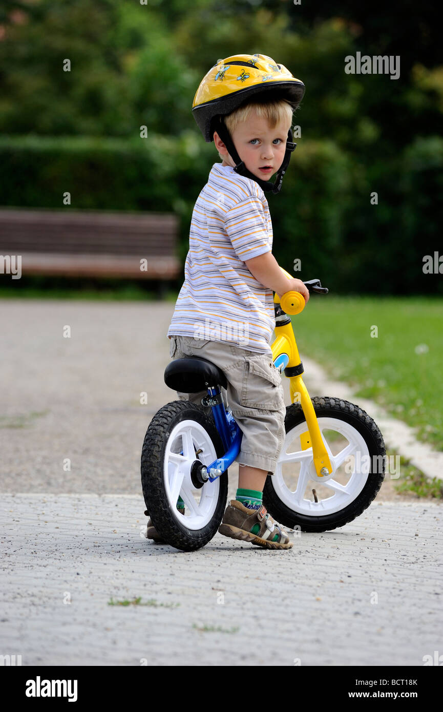 Little child boy riding a bounce bicycle with bike helmet Stock Photo ...