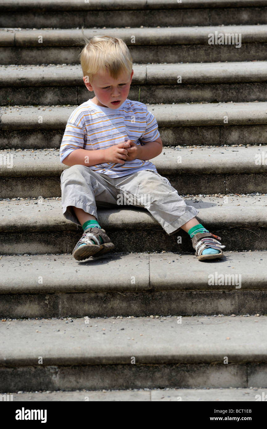 Little Blond Boy Sitting on Steps Stock Photo - Alamy
