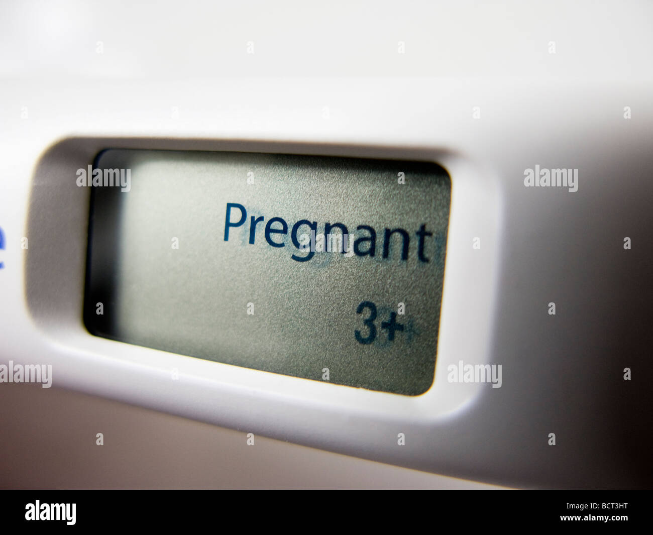 A pregnancy test device showing a positive pregnant result on the LCD ...