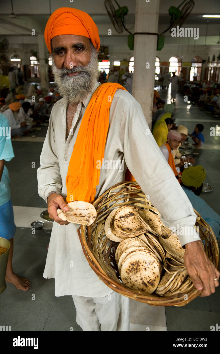 Sikh man serving bread to pilgrims at a free meal at the Community ...