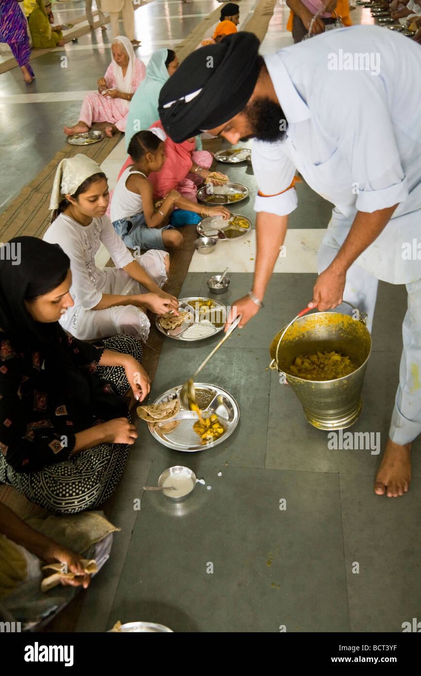 Sikh man serving curry to pilgrims at a free meal at the Community ...