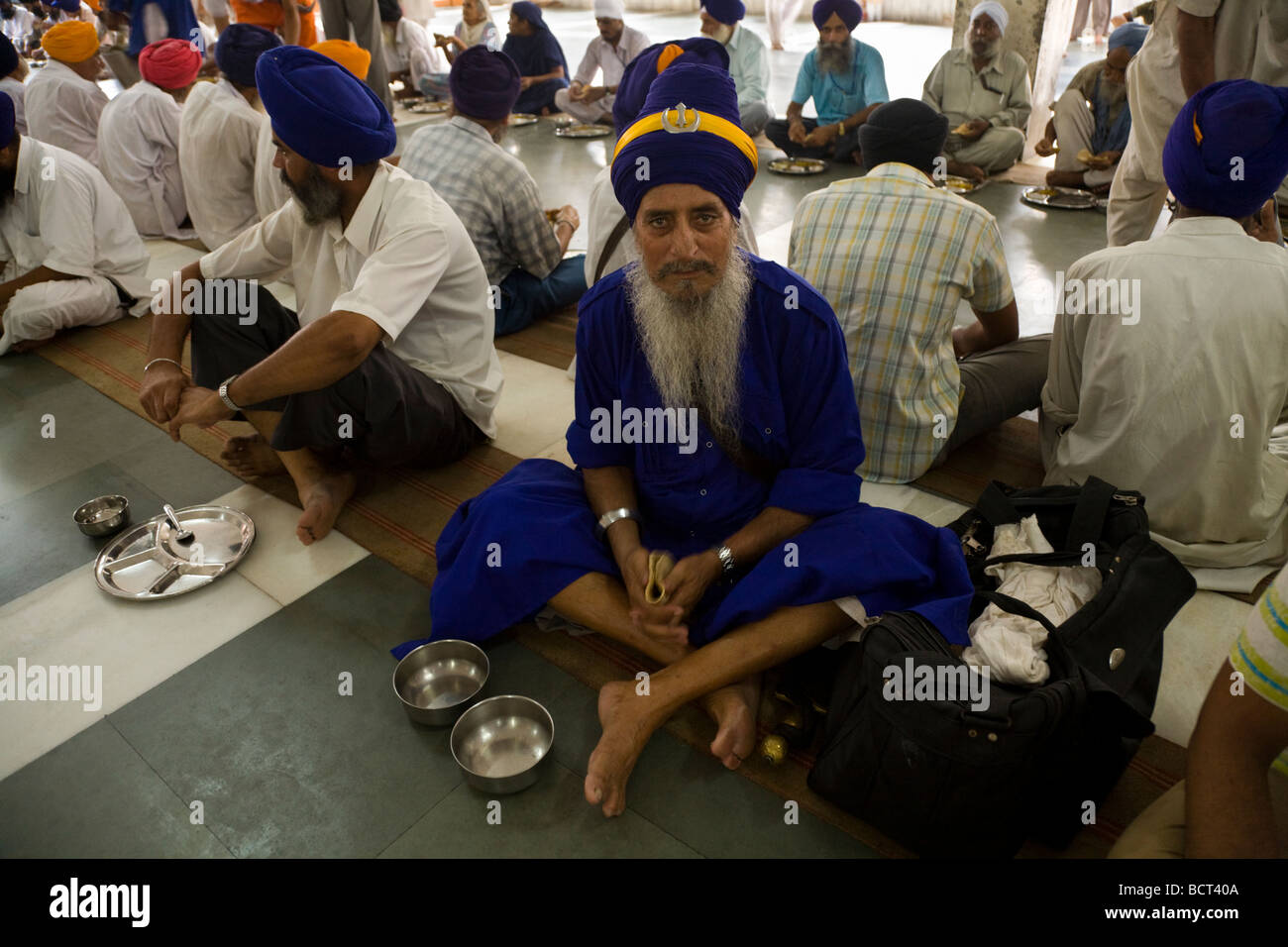 Sikh man waits to eat a free meal at the Community kitchen in the ...