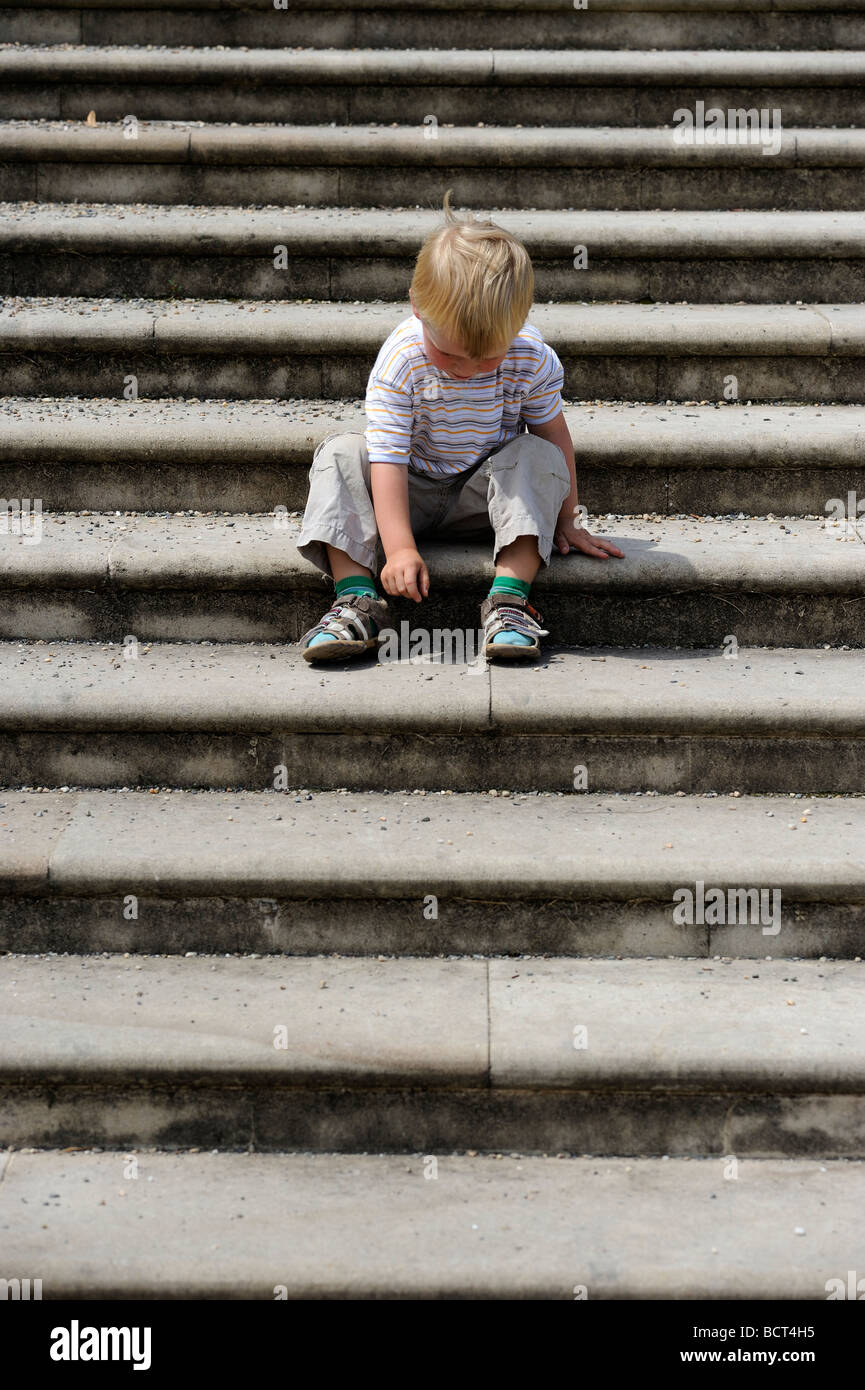 Little Blond Boy Sitting on Steps Stock Photo - Alamy