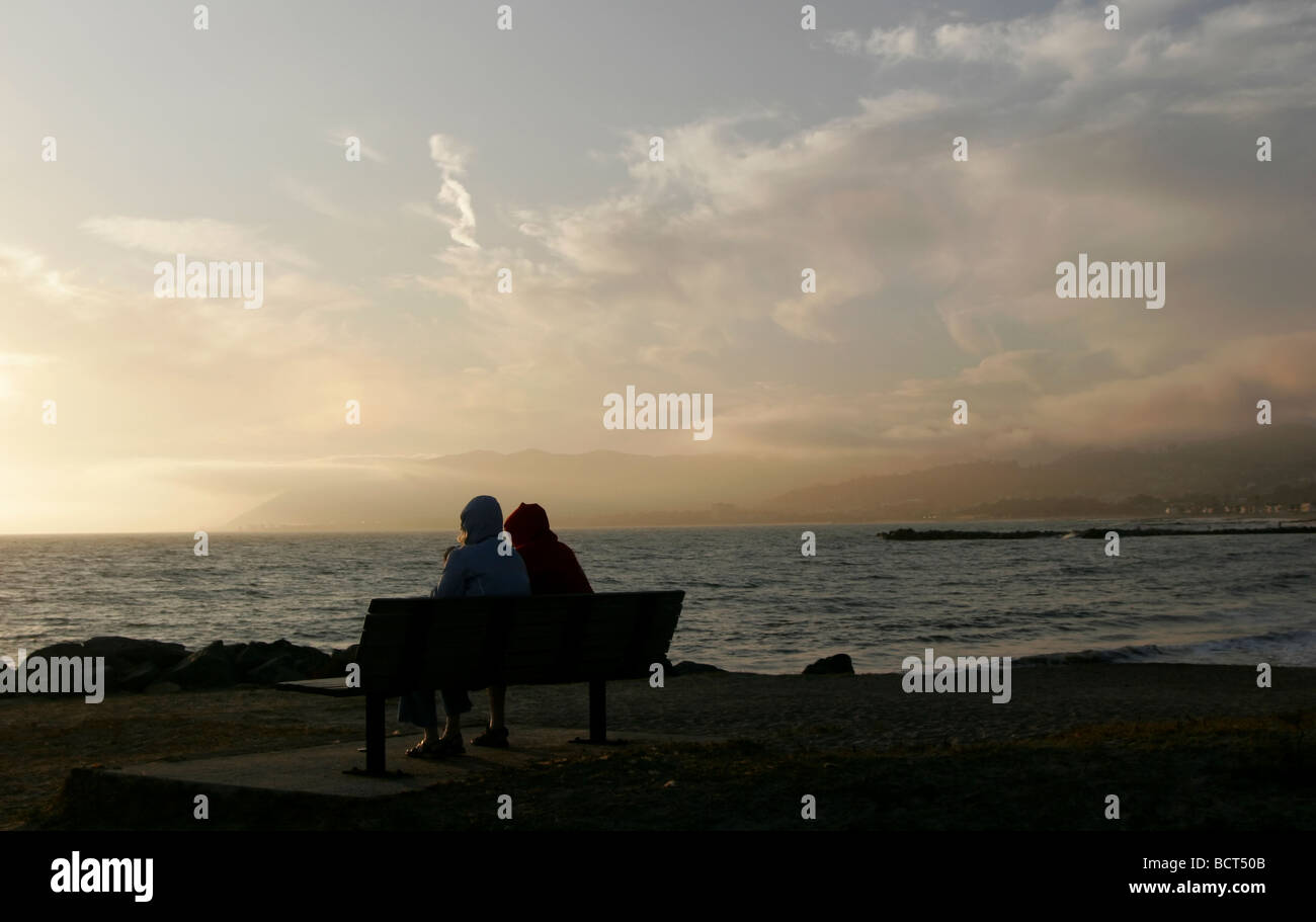 People sitting on a bench watching a sunset hi-res stock photography ...