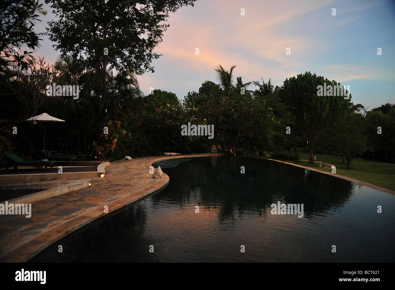 Swimmingpool in a resort at sunset Stock Photo - Alamy