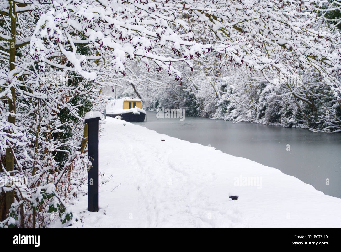 SNow covered path and canal boat on the Oxford Canal Stock Photo - Alamy