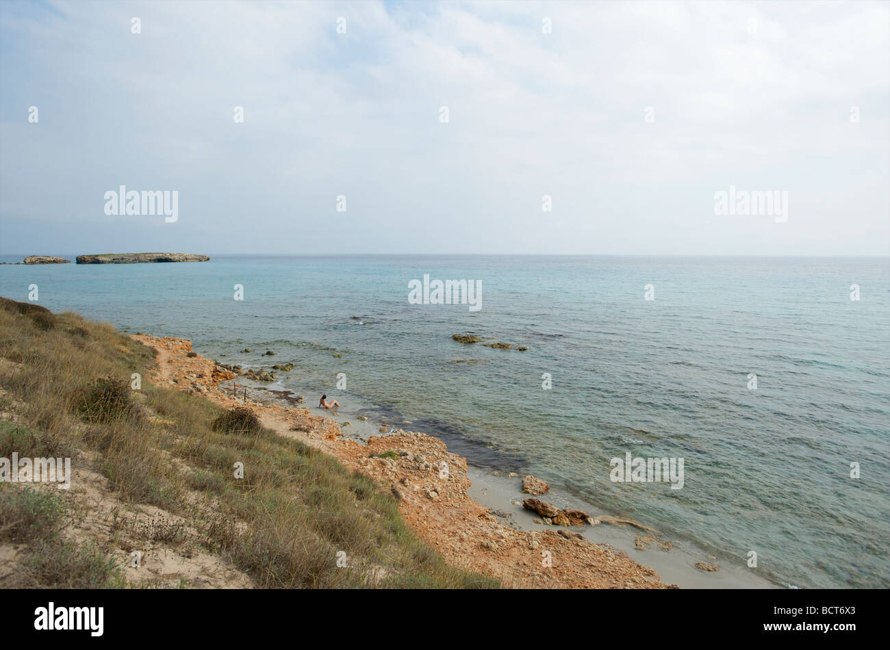 A lone nude bather on the beach of Binigaus on the Balearic island of ...