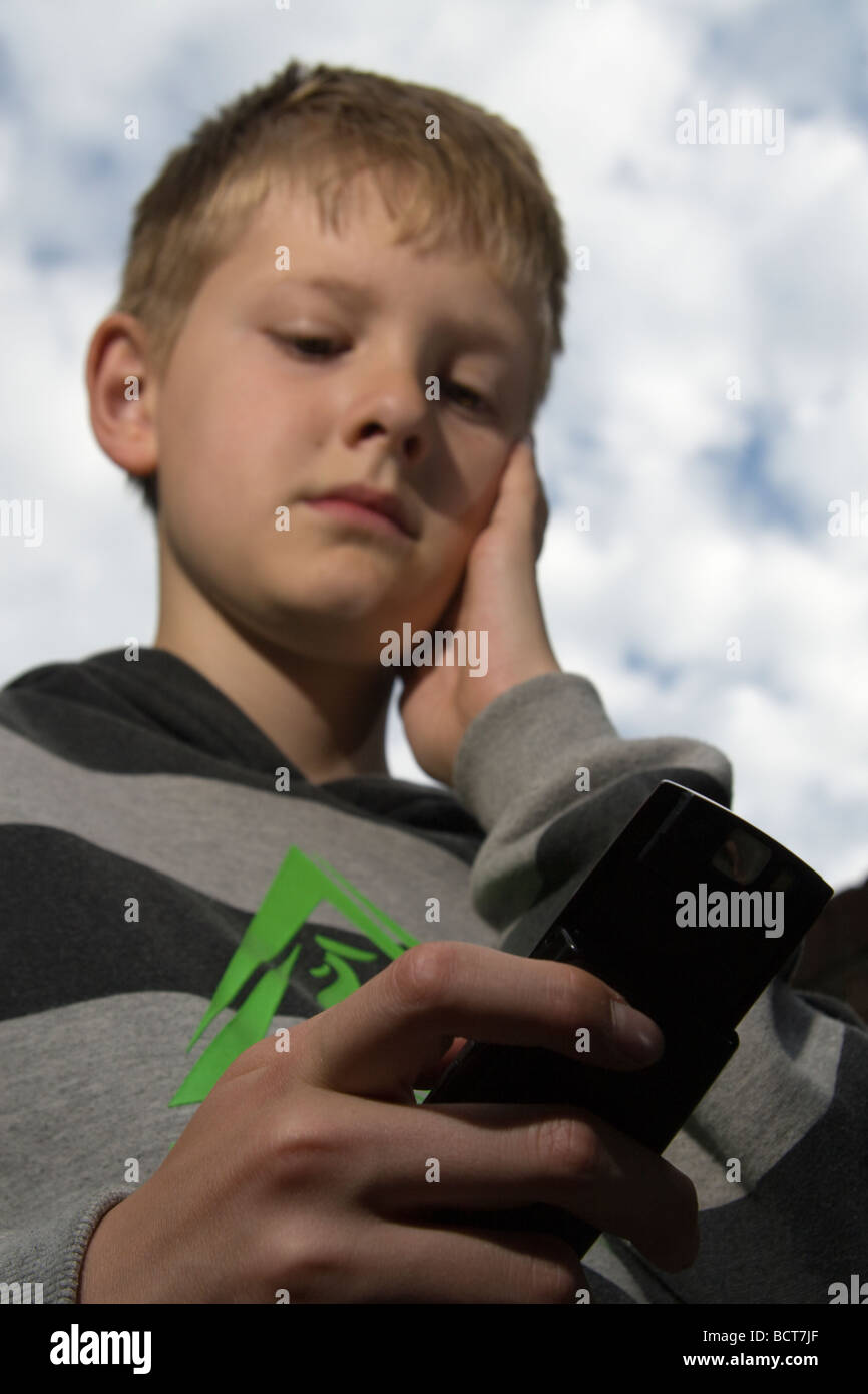 A teenage boy looking worriedly at his mobile phone Stock Photo - Alamy