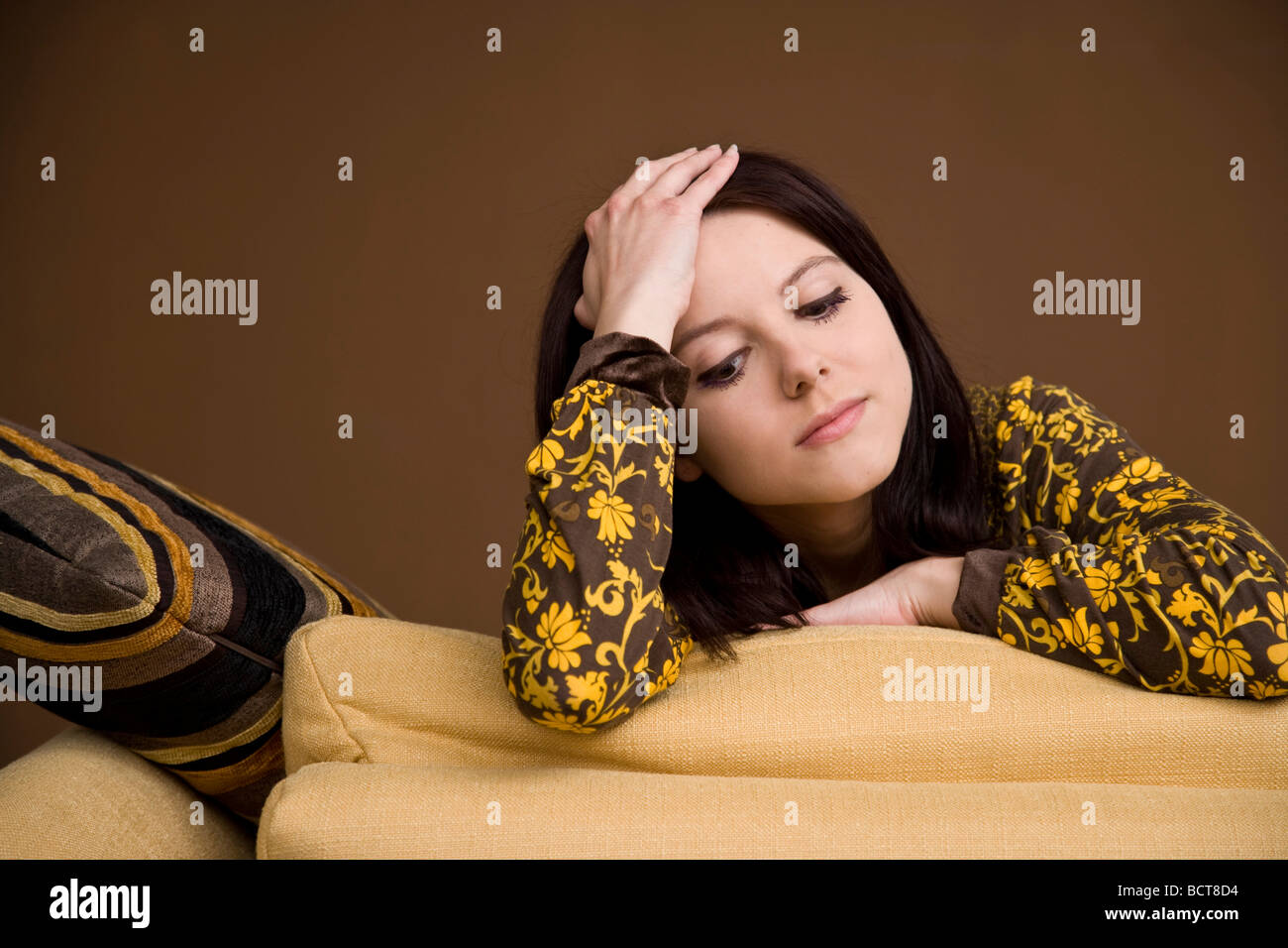 Girl leaning on a sofa Stock Photo - Alamy