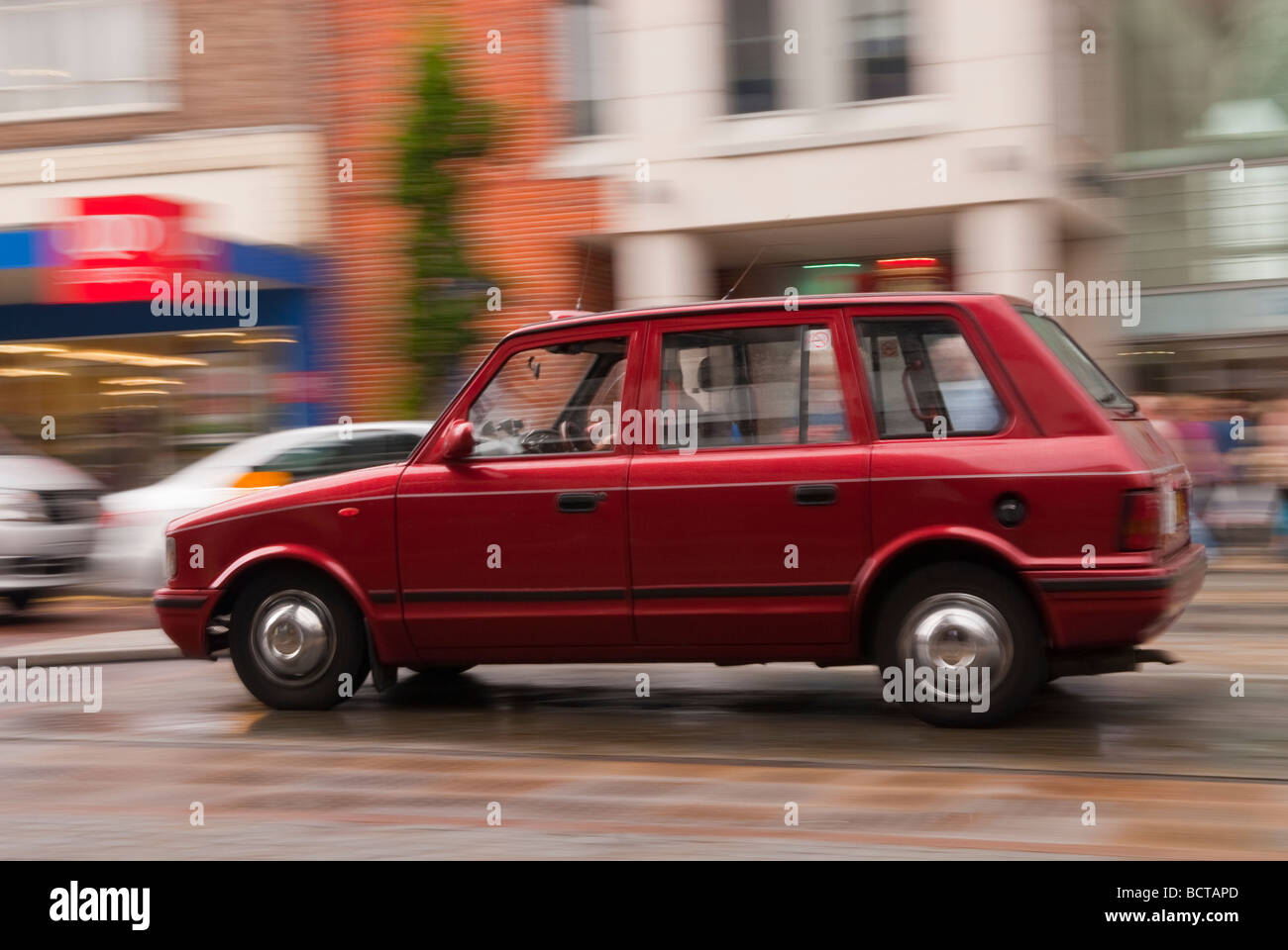 A taxi driving through the city centre in the rain showing movement in ...