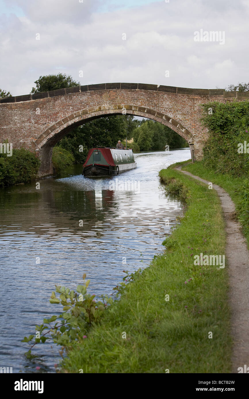 A narrow boat navigates along Bridgewater Canal and passes under an ...