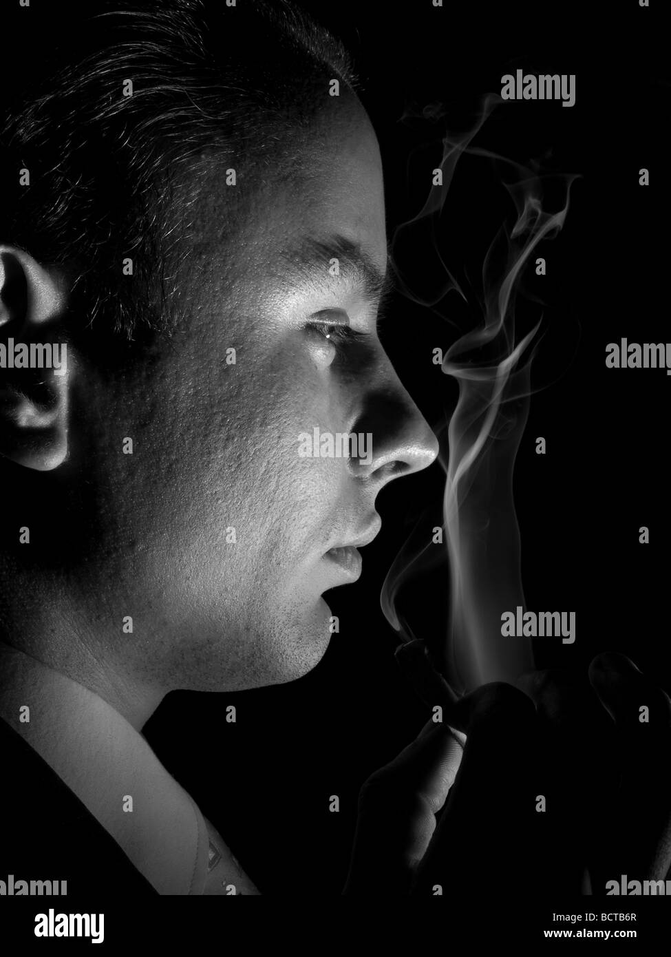 Young man in suit smoking cigarette sideview Stock Photo - Alamy