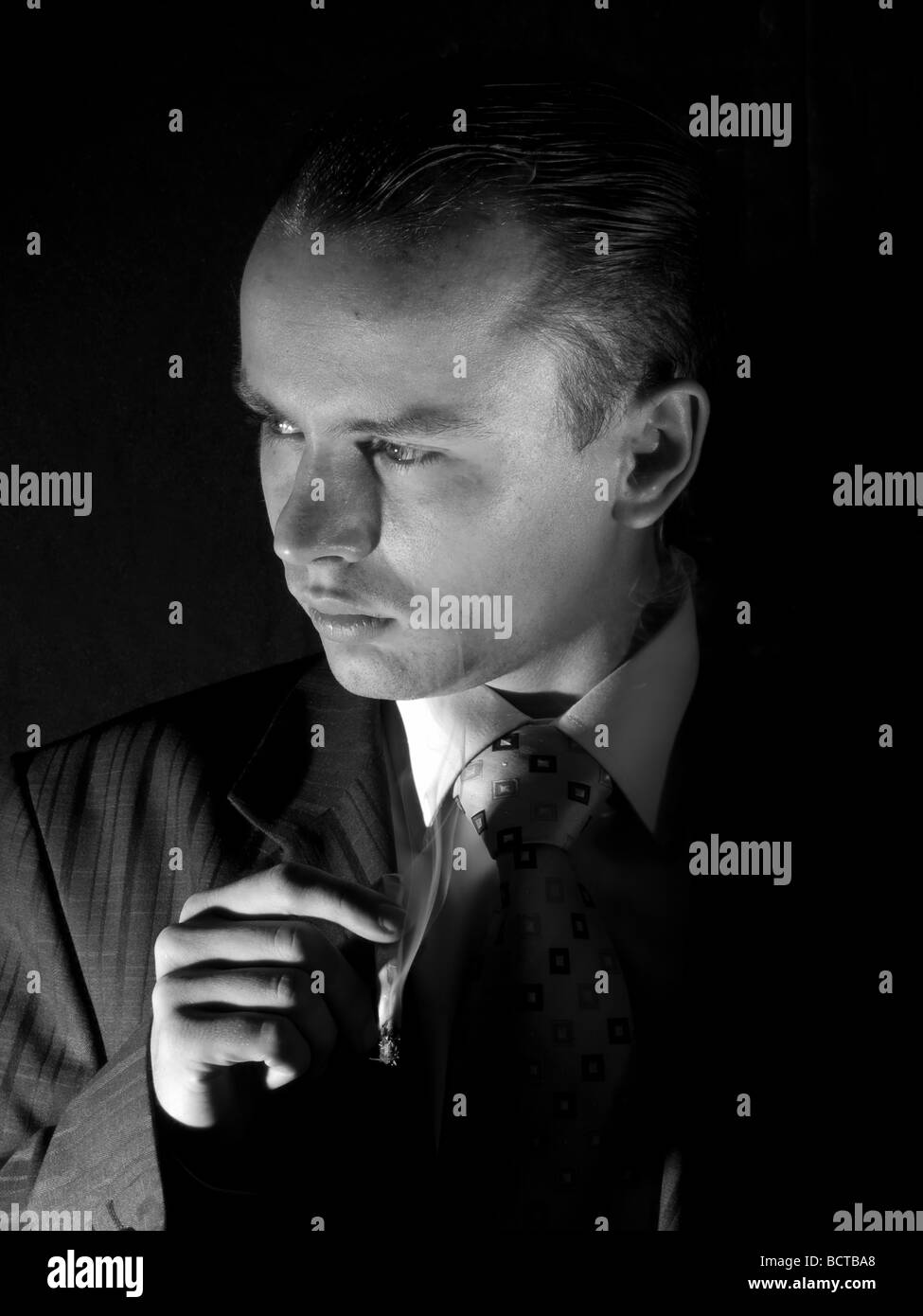Young man in suit smoking cigarette side view Stock Photo - Alamy