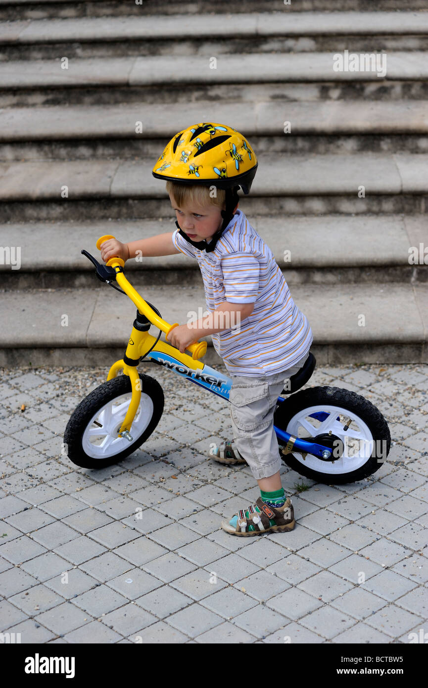 Little child boy riding a bounce bicycle with bike helmet Stock Photo ...