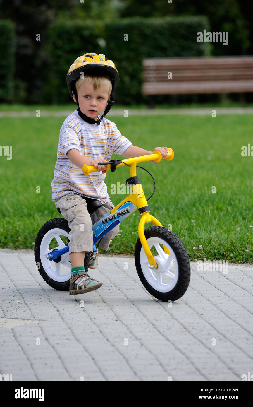 Little child boy riding a bounce bicycle with bike helmet Stock Photo ...