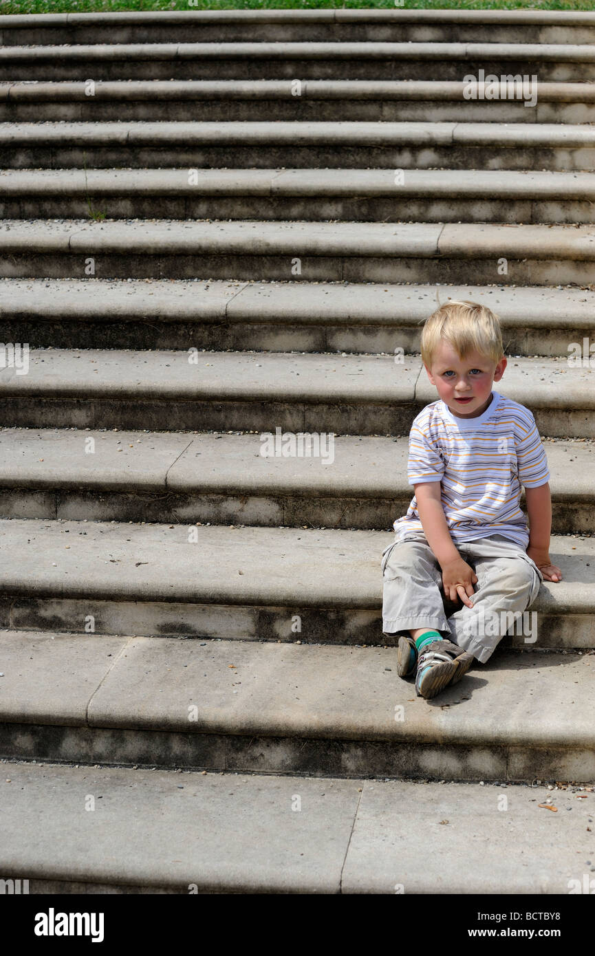 Little Blond Boy Sitting on Steps Stock Photo - Alamy