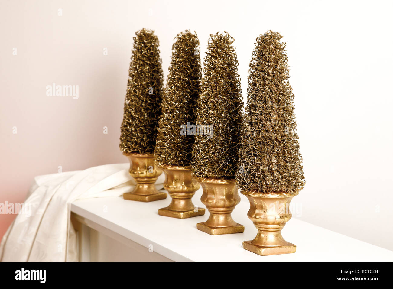 Four small golden fir trees on a fireplace Stock Photo - Alamy