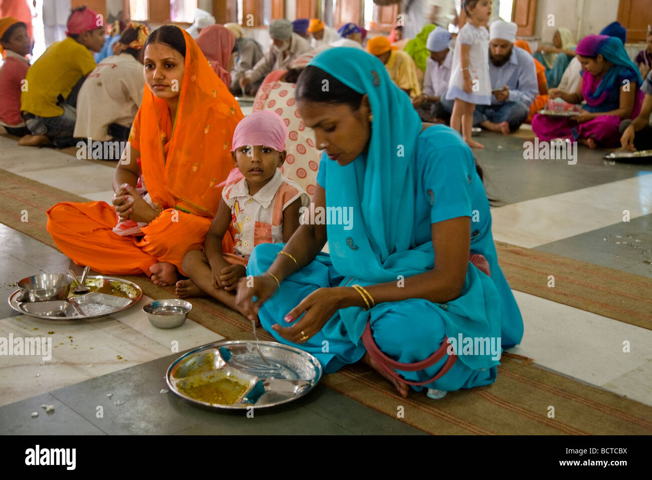 Sikh women eating a free meal served in the Community kitchen at the ...