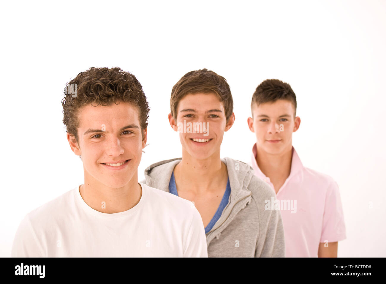 Three boys standing behind each other Stock Photo - Alamy
