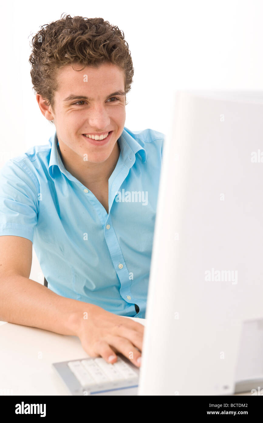 Boy smiling, working on his computer Stock Photo - Alamy