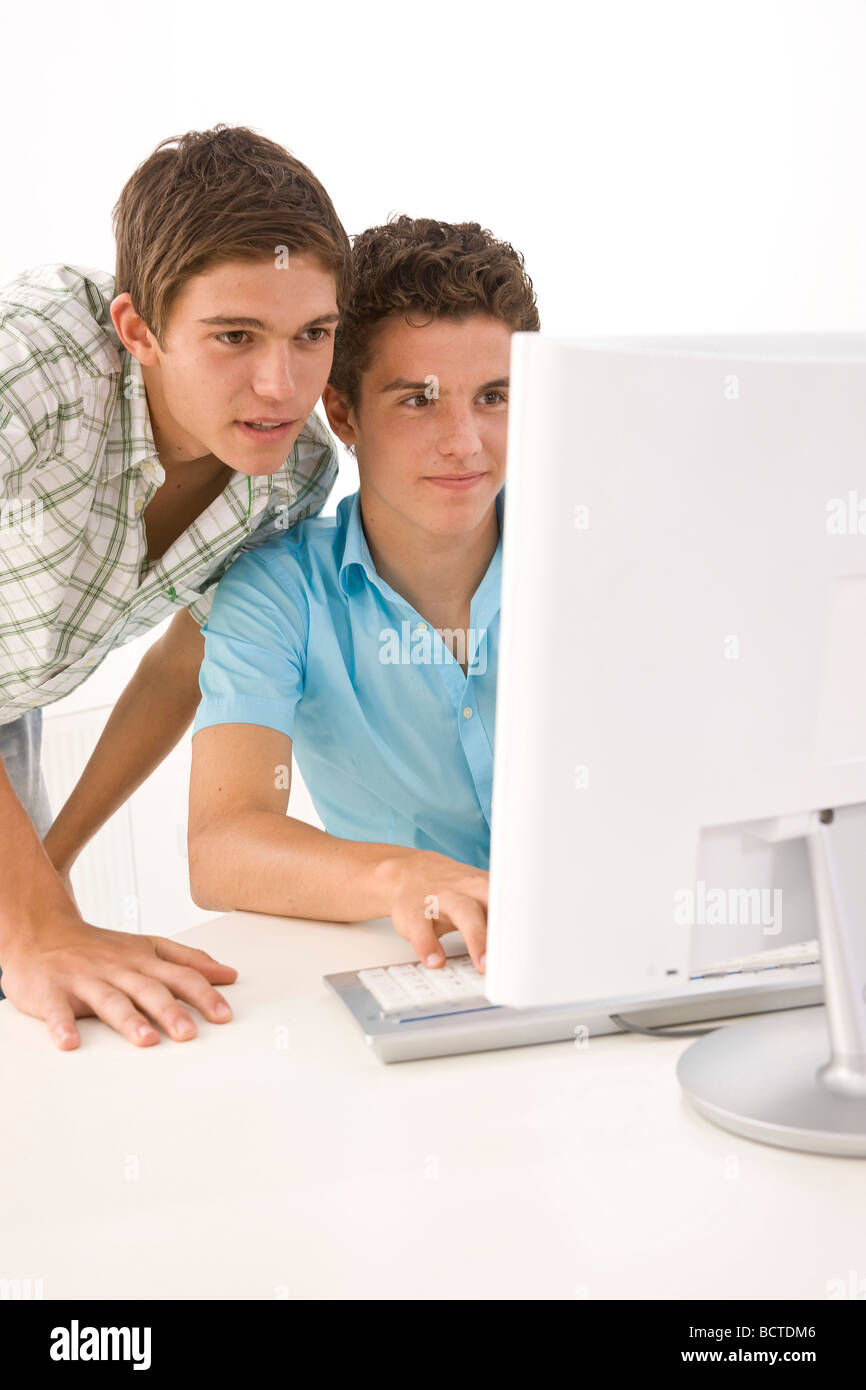 Two boys working on a computer Stock Photo - Alamy