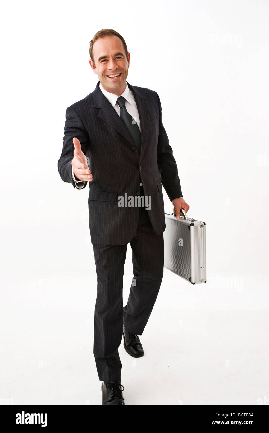 Businessman laughing, hand stretched out to shake hands Stock Photo - Alamy