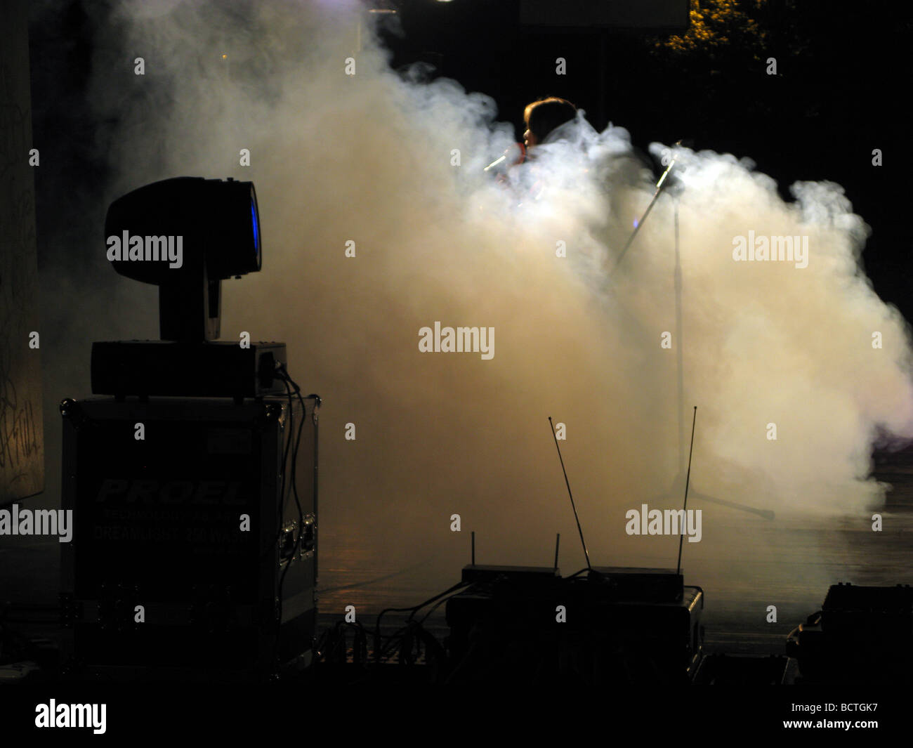 female singer on stage with smoke effect screen at night Stock Photo ...