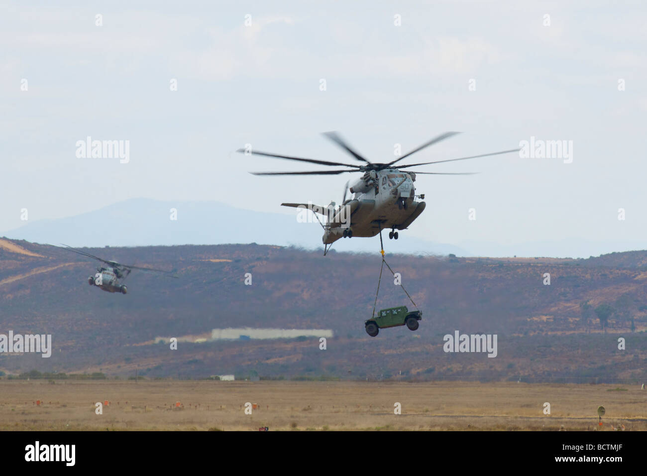 Large military helicopters deploying land vehicles in a tactical ... Large military helicopters deploying land vehicles in a tactical ...