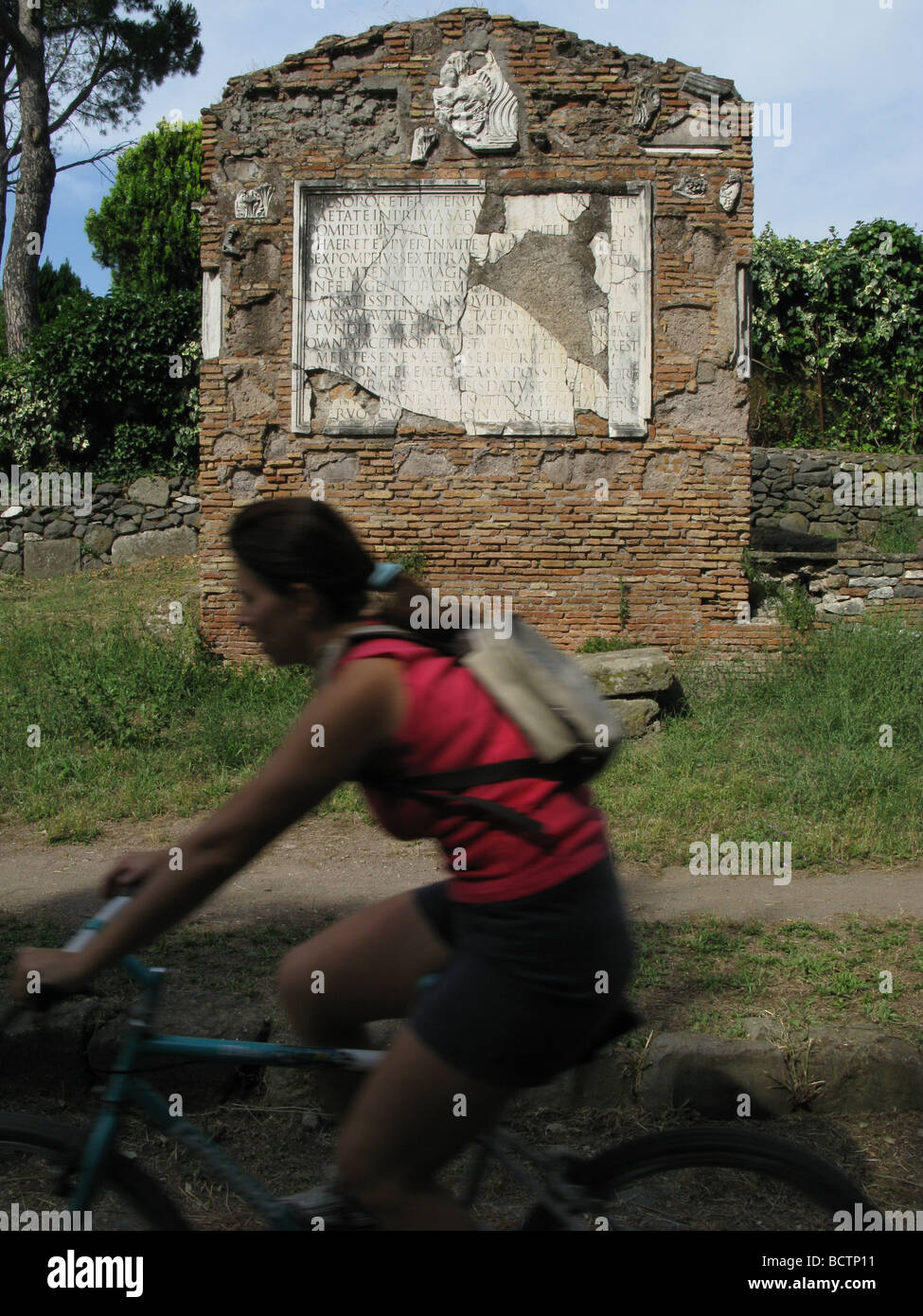 person riding bike on the ancient roman old appian way, rome, italy ...