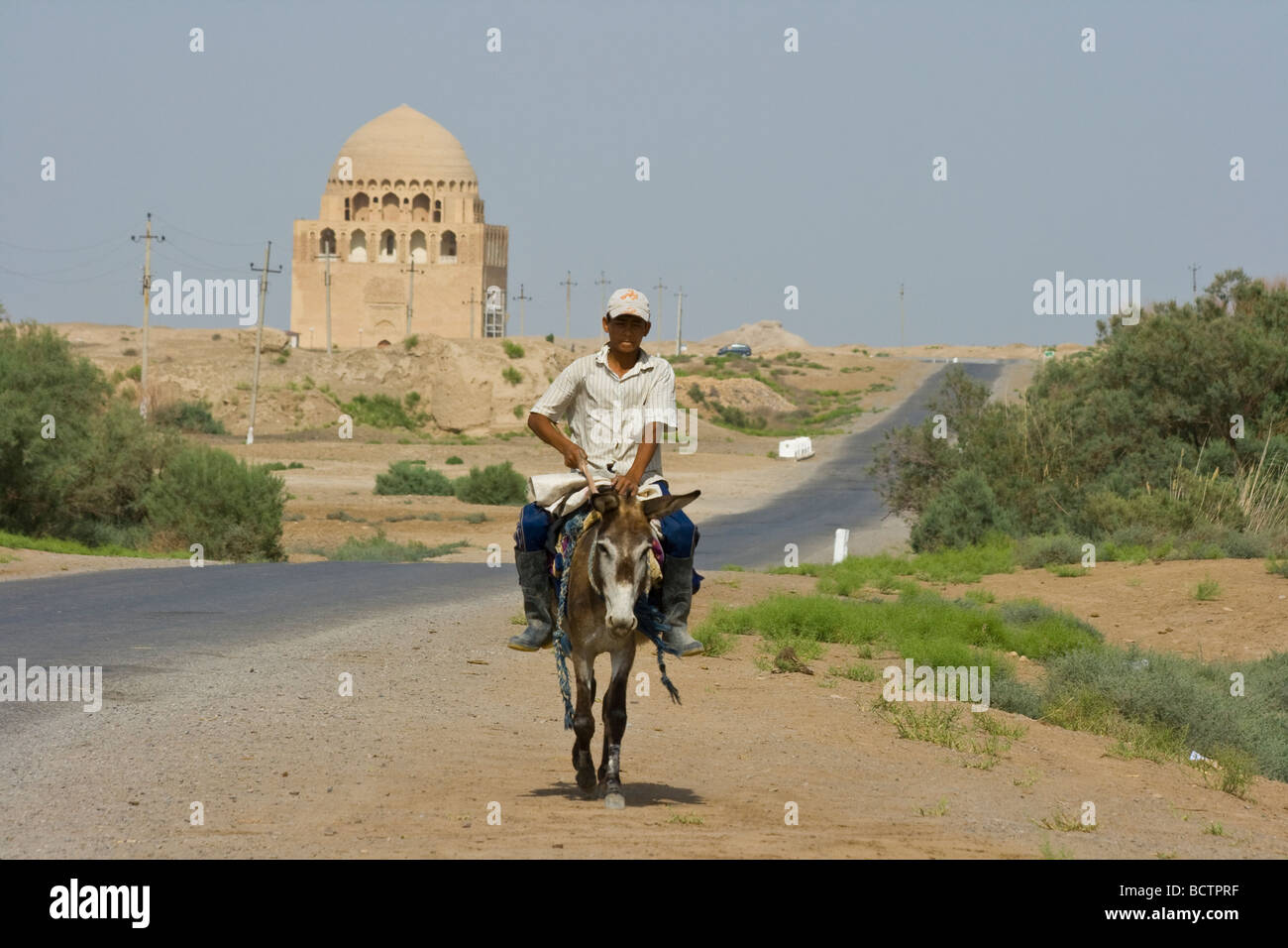 Boy Riding Donkey and Mausoleum of Sultan Ahmad Sanjar in the Ruins of ...