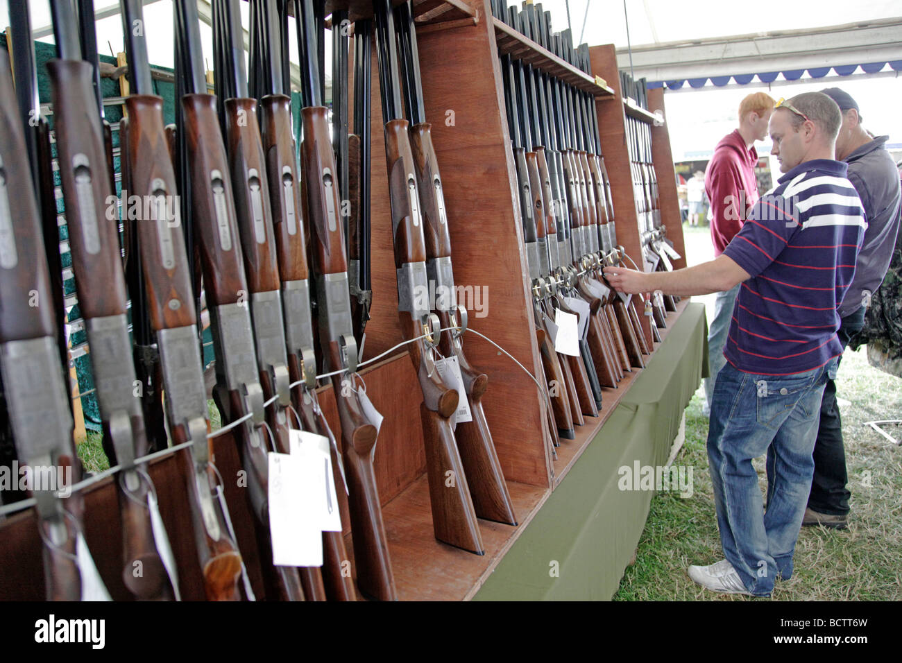 Customers check out shotguns on display at a country fair Stock Photo ...